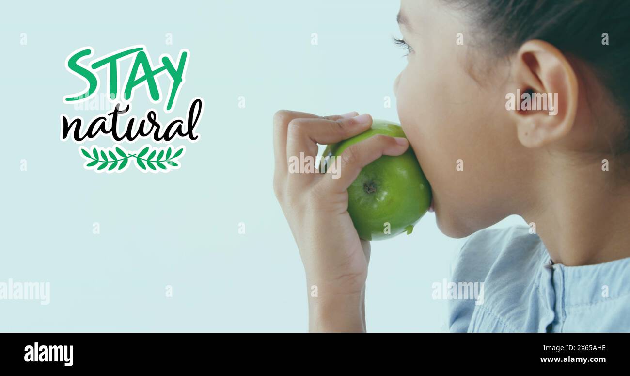 Image of stay natural text over biracial girl eating green apple Stock ...
