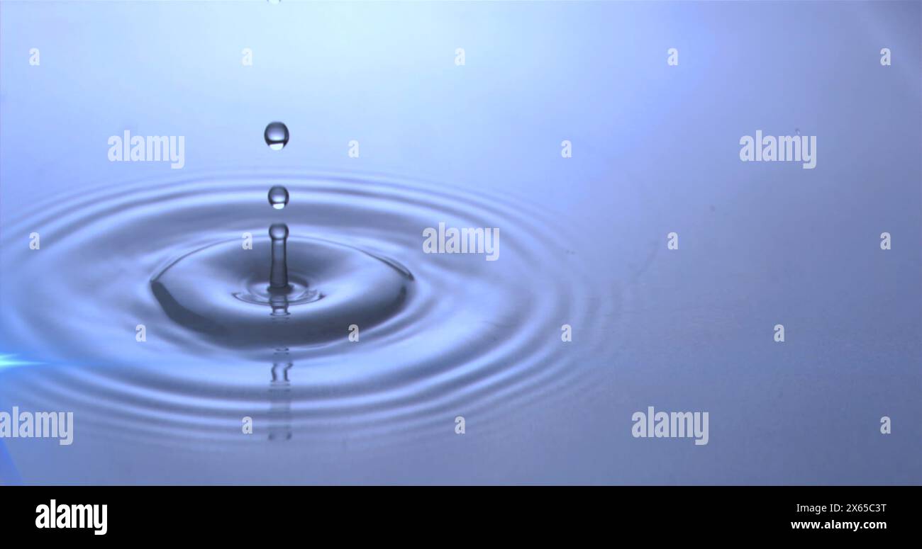 Image of water drops dropping into blue water with glowing light Stock ...
