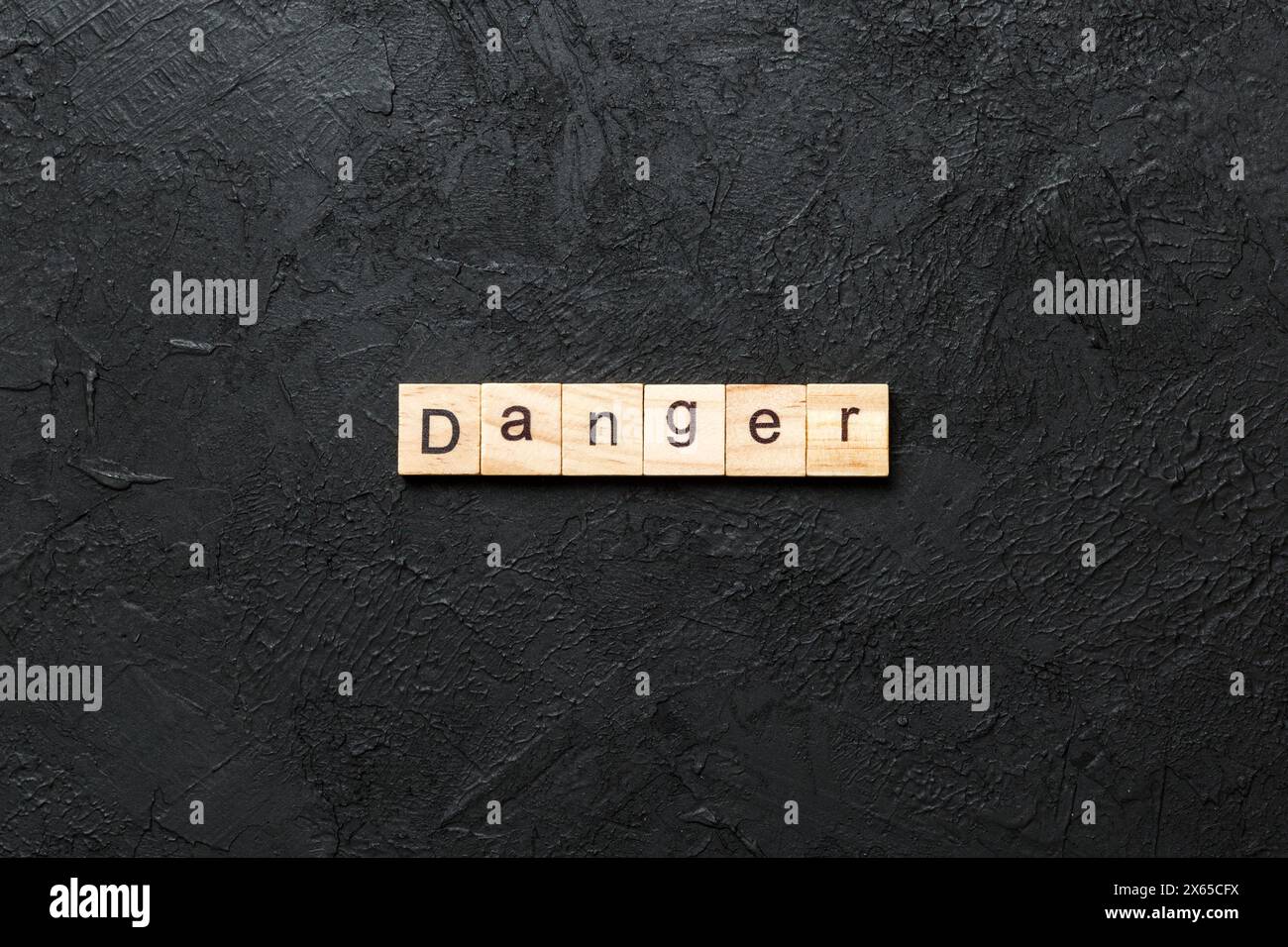 Danger word written on wood block. Danger text on cement table for your ...