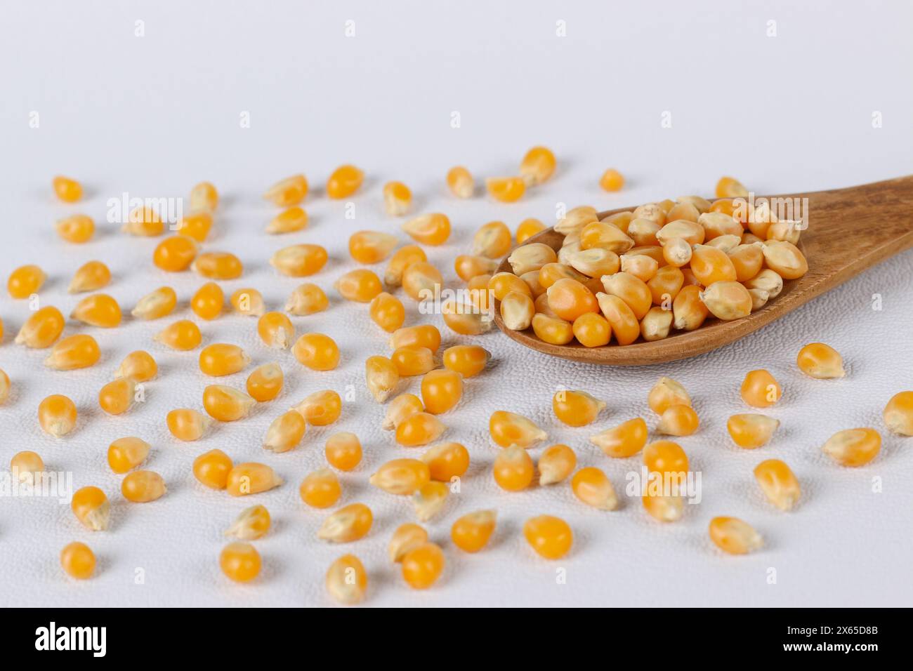 Dried corn or maize kernels on white background with spoon Stock Photo ...