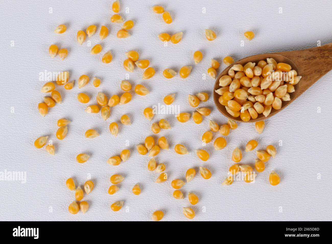 Dried corn or maize kernels on white background with spoon Stock Photo ...