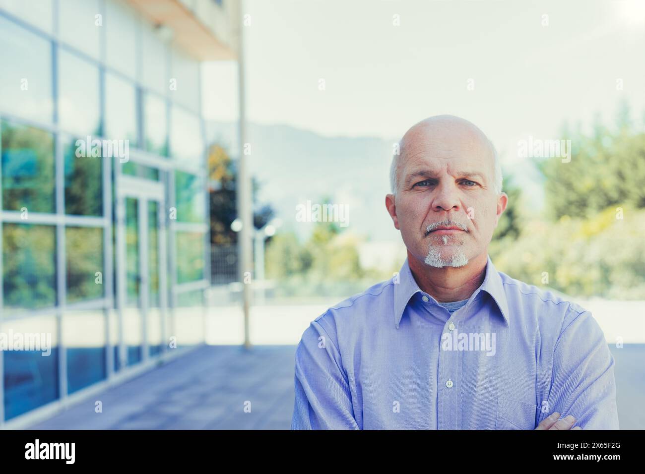Distinguished man in professional attire stands confidently by a modern ...