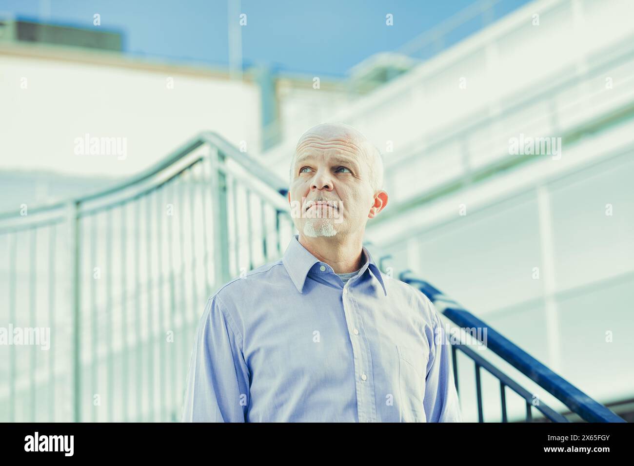 Mature man stands confidently outdoors, blue shirt enhancing his wise ...