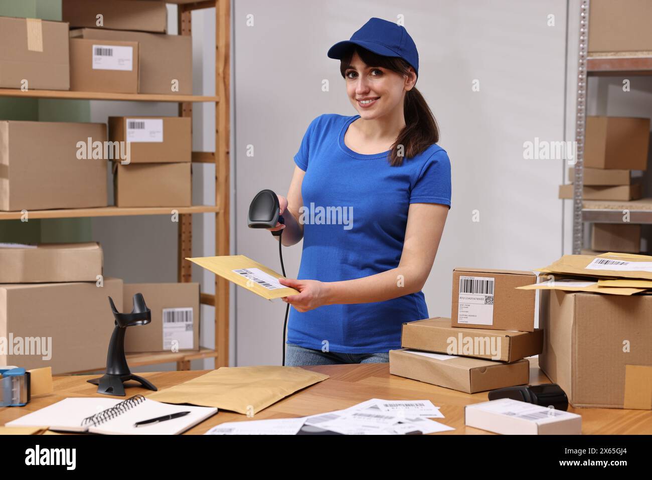 Parcel packing. Post office worker with scanner reading barcode at ...