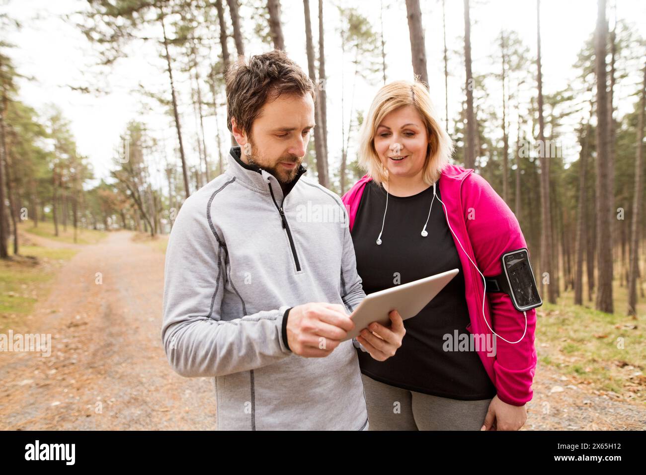 Overweight woman resting after run, personal trainer checking her ...