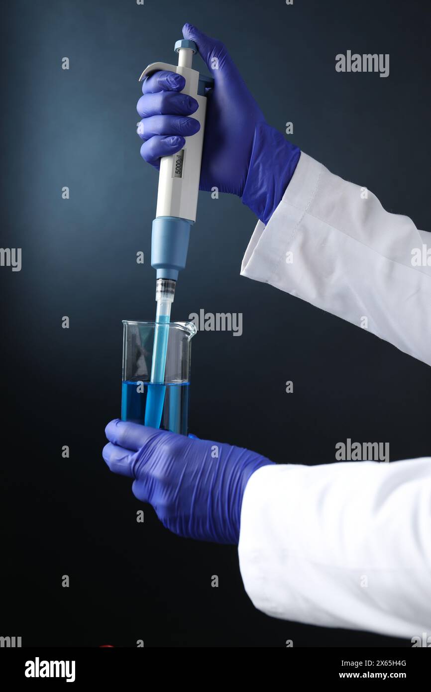 Laboratory analysis. Scientist dripping sample with micropipette into ...