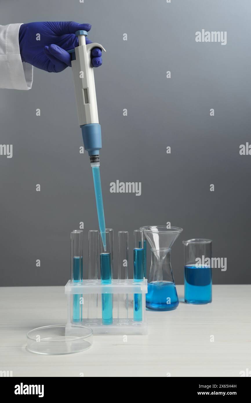 Laboratory analysis. Scientist dripping sample with micropipette into ...