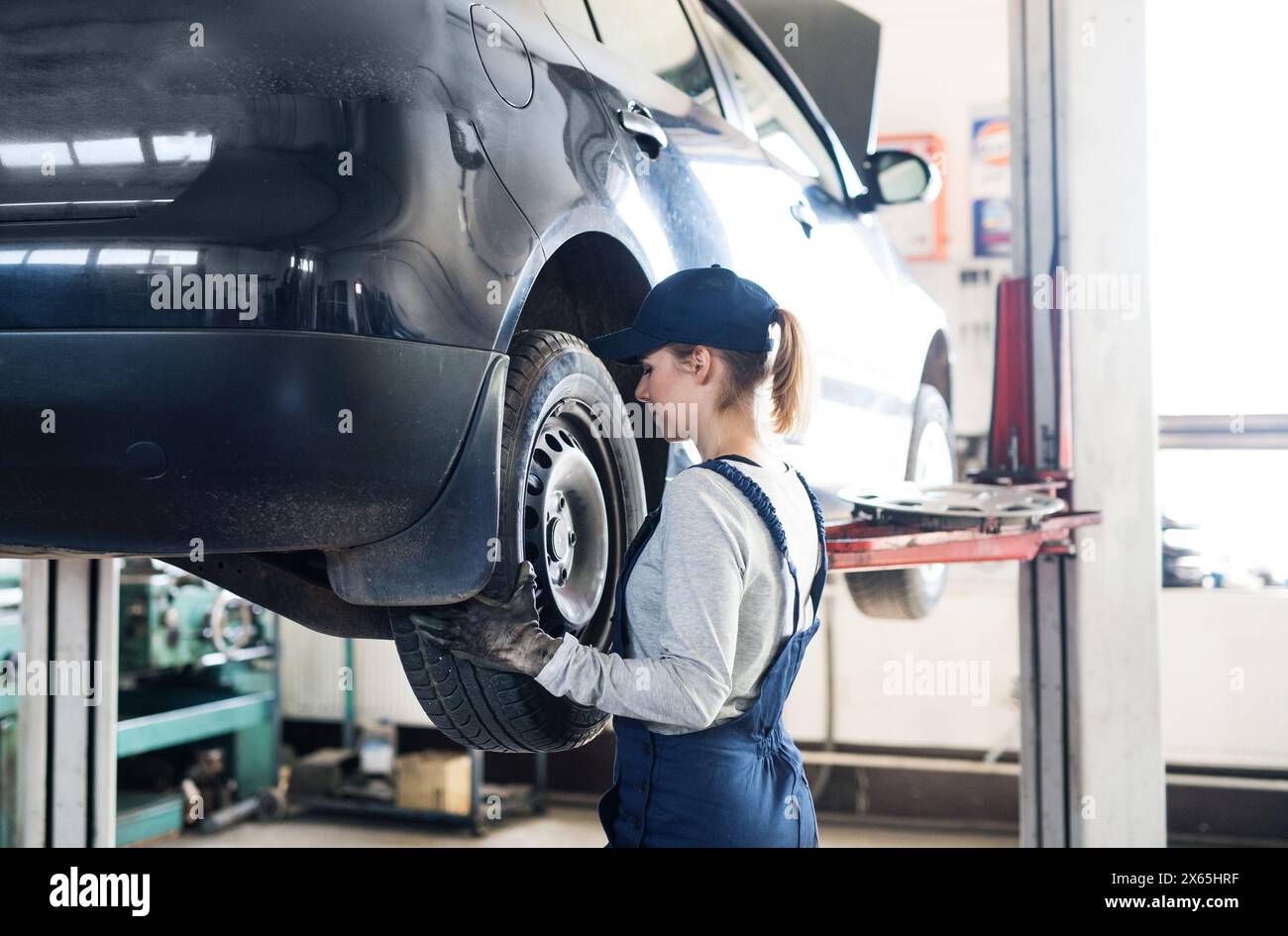Female auto mechanic changing tieres in auto service. Beautiful woman ...