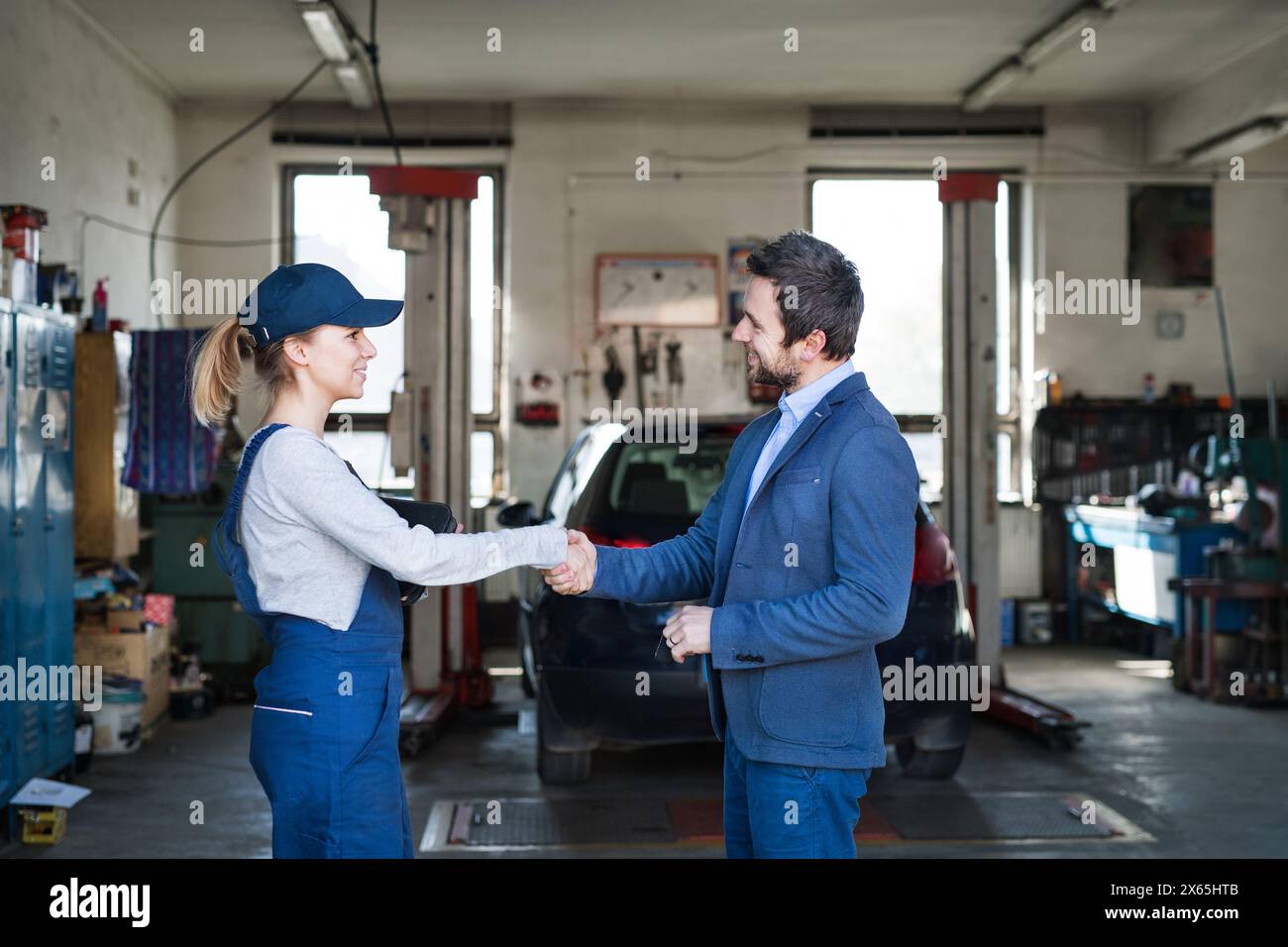 Happy customer shaking hands with mechanics hi-res stock photography ...
