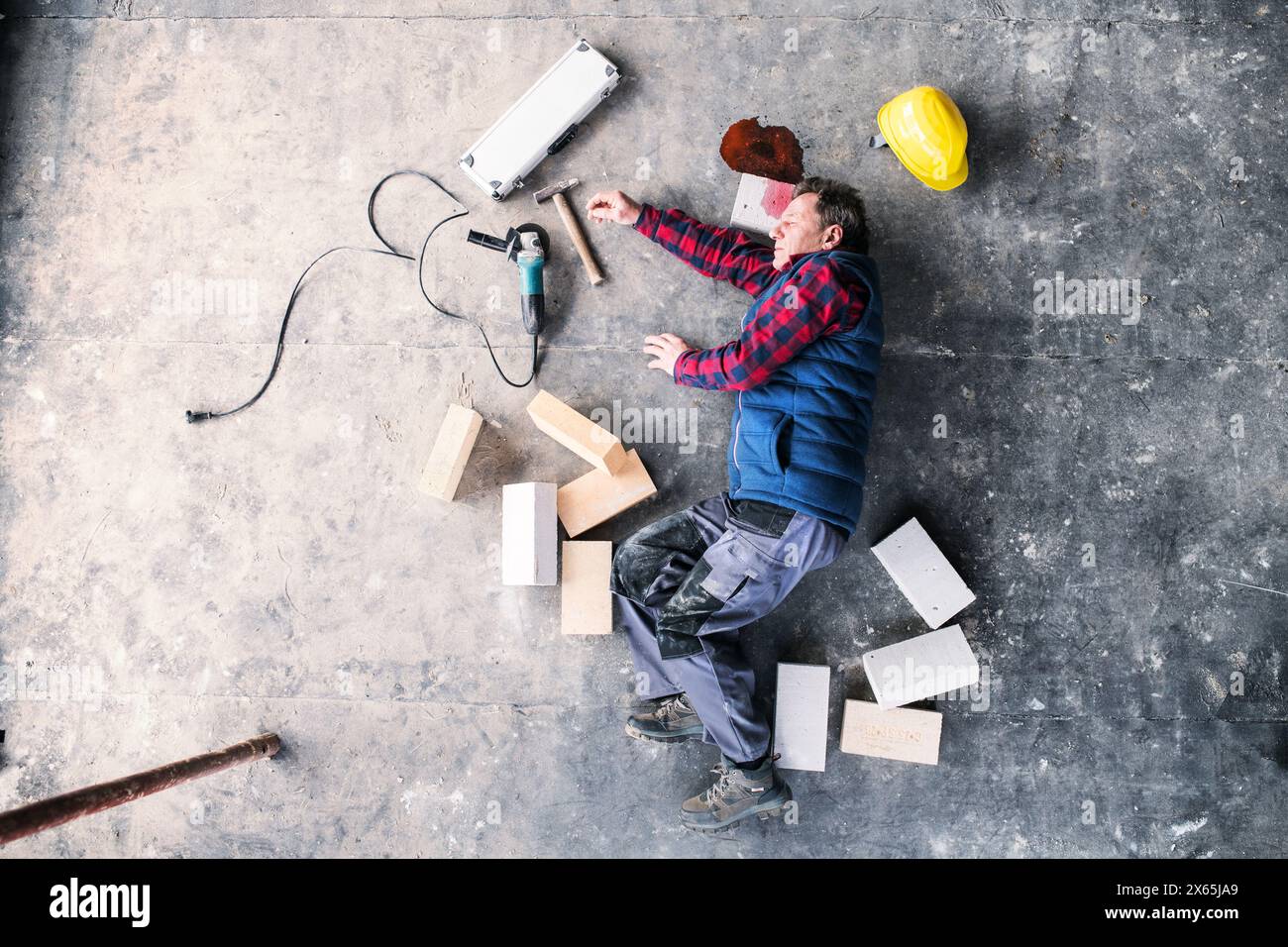 An unconscious man worker lying on the floor after a head injury. Work ...