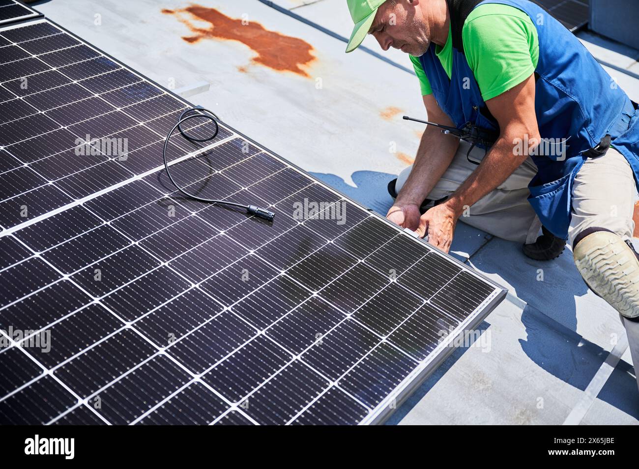 Worker building solar panel system on metal rooftop of house. Man ...