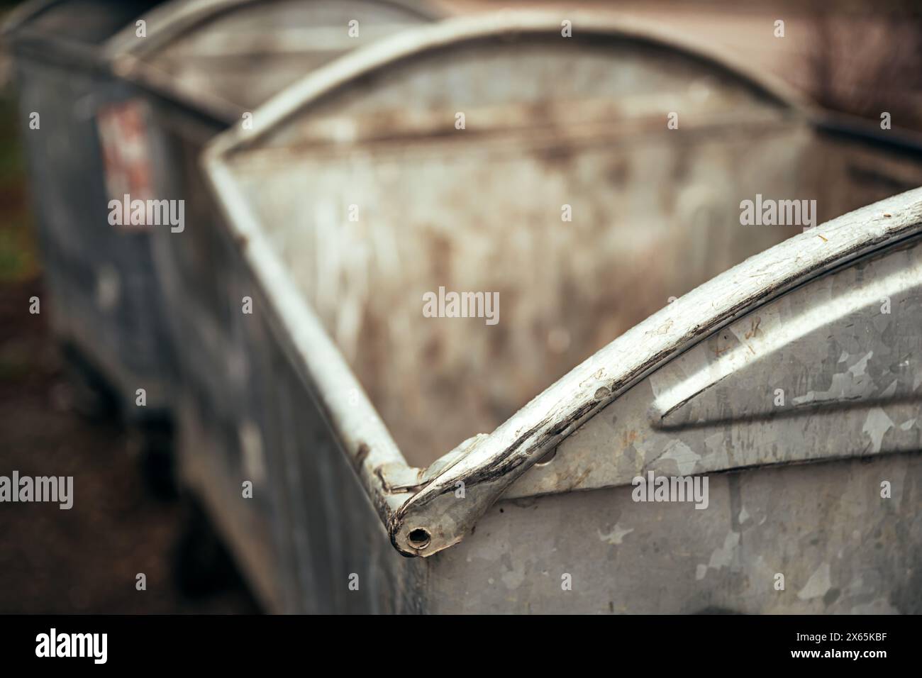 Worn old metallic garbage dumpster container or dust bins at the street ...