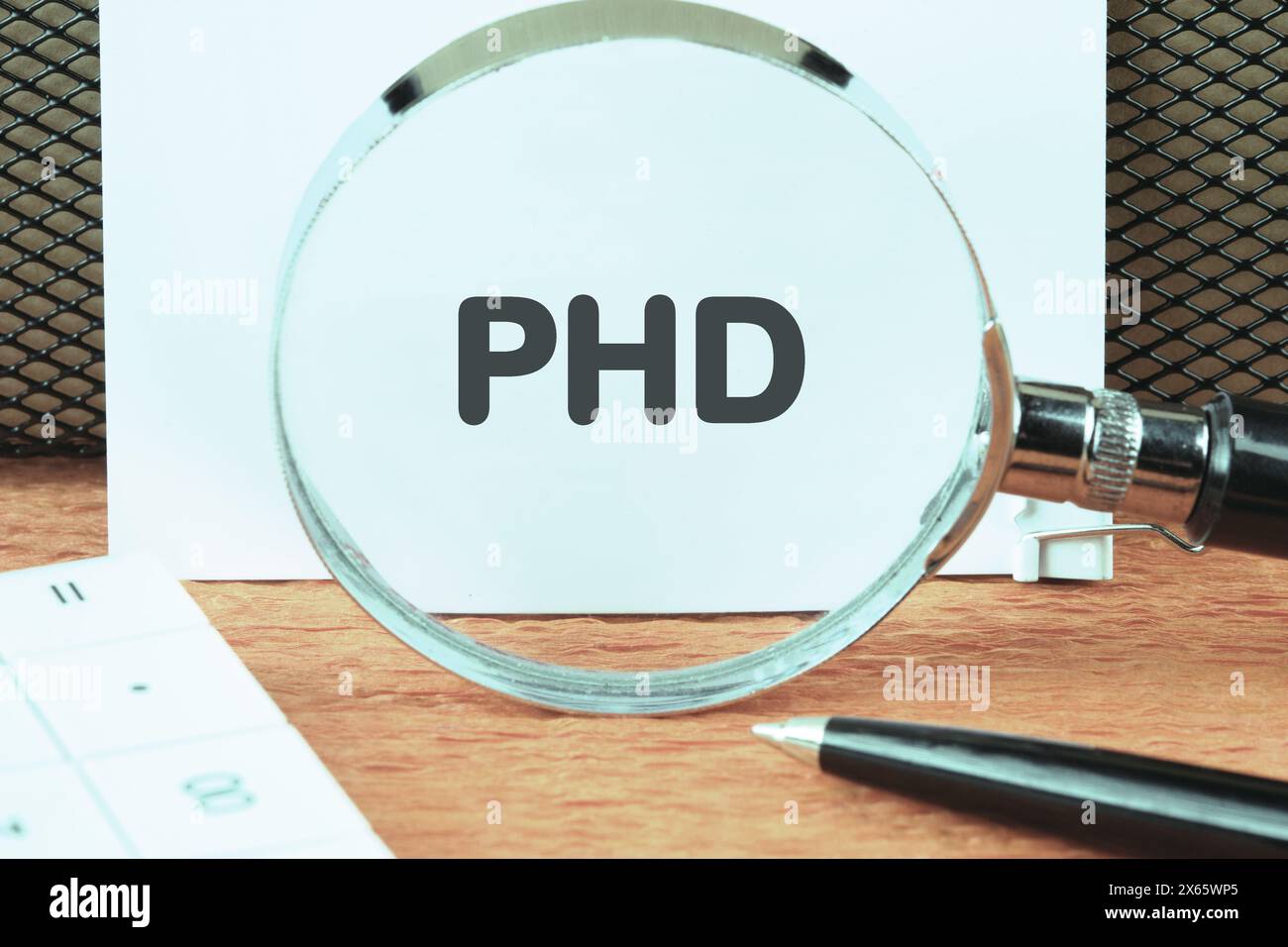 Word PhD. Doctor of Philosophy. PHD through a magnifying glass on a ...