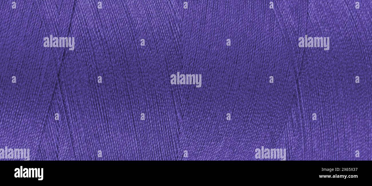 Texture of purple color threads in spool close up, macro. Wide banner ...