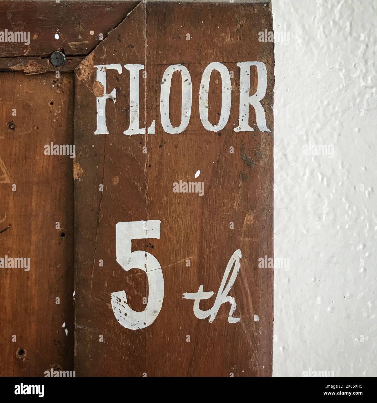 Hand painted fifth floor sign pained on door frame Stock Photo - Alamy