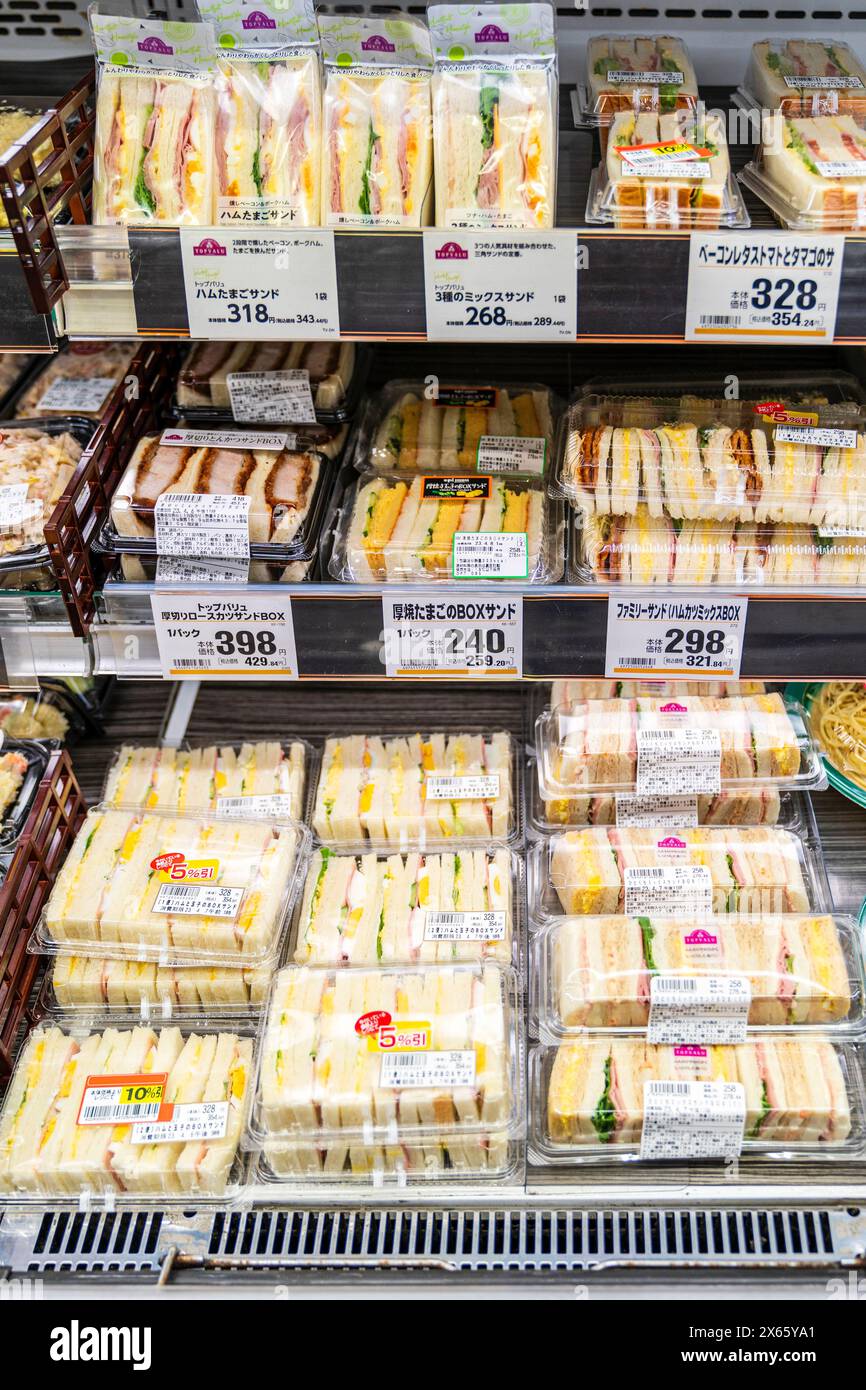 Three supermarket shelves of various Japanese style Western sandwiches ...