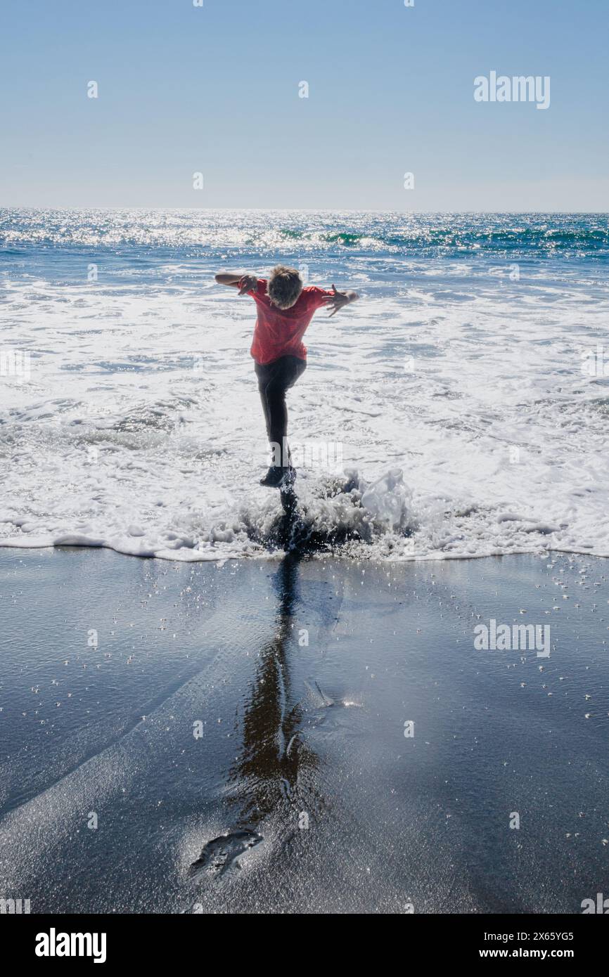 Boy running into the waves hi-res stock photography and images - Alamy