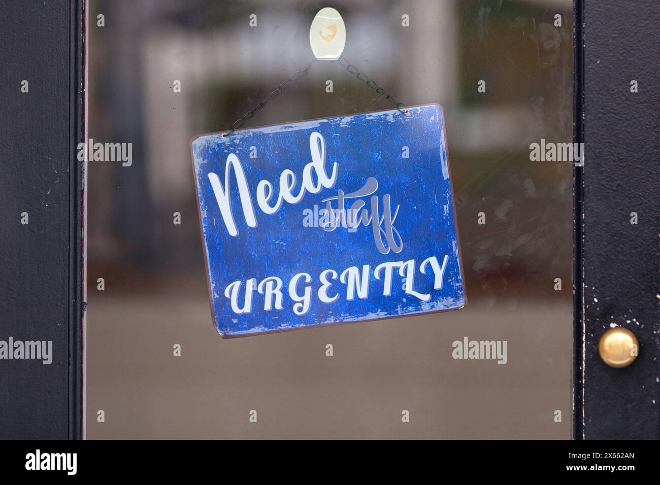Blue open sign with written in "Need staff urgently Stock Photo - Alamy