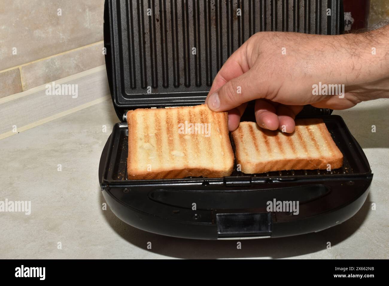 A man's hand removes ready-to-eat fried bread from a toaster Stock ...