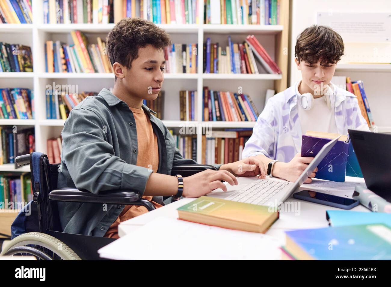 Side view portrait of young teenage boy with disability using laptop ...