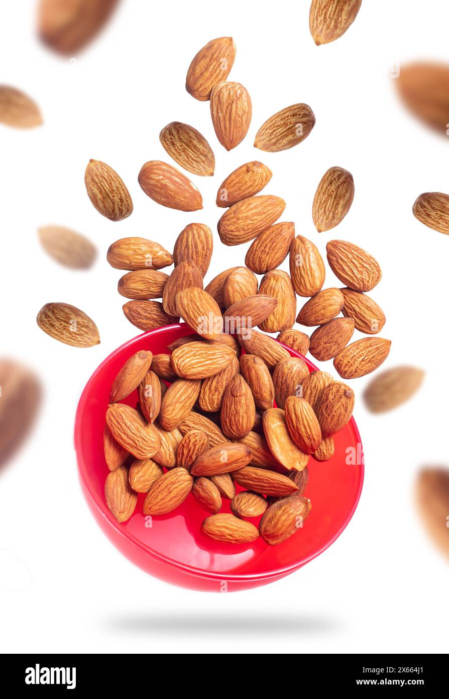 Almond falling in red cup isolated on white background with clipping ...