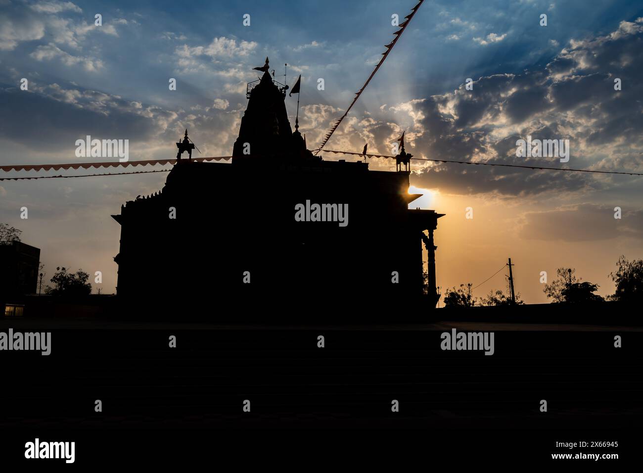 backlit shot of dramatic sunset sky and artistic hindu temple at ...