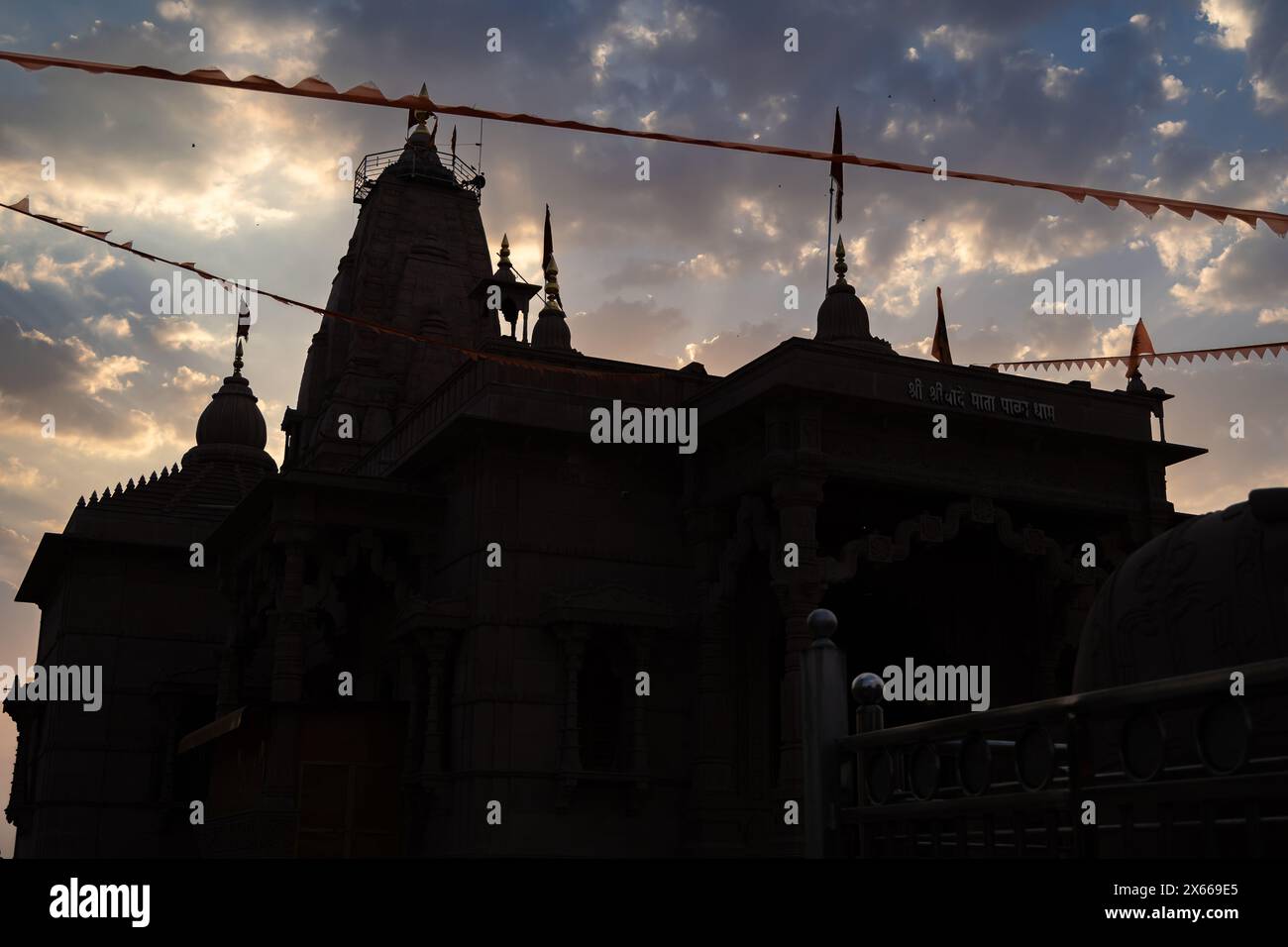 backlit shot of dramatic sunset sky and artistic hindu temple at ...