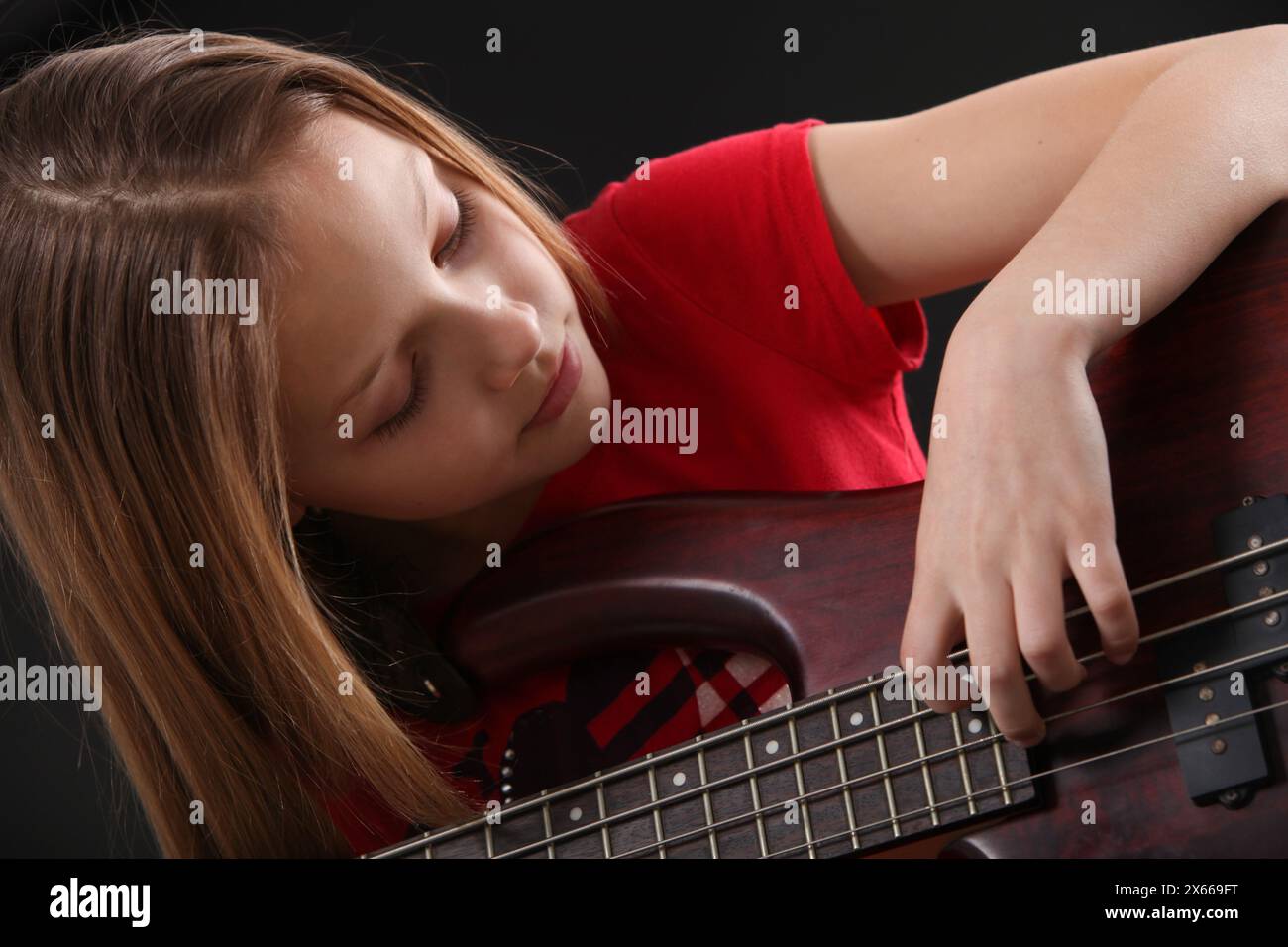 enthusiastic girl playing bass guitar Stock Photo - Alamy