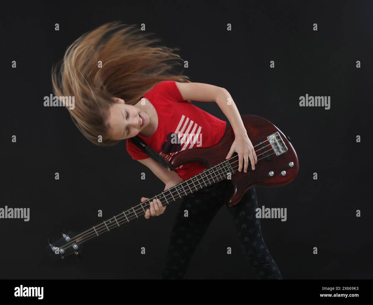 enthusiastic girl playing bass guitar Stock Photo - Alamy
