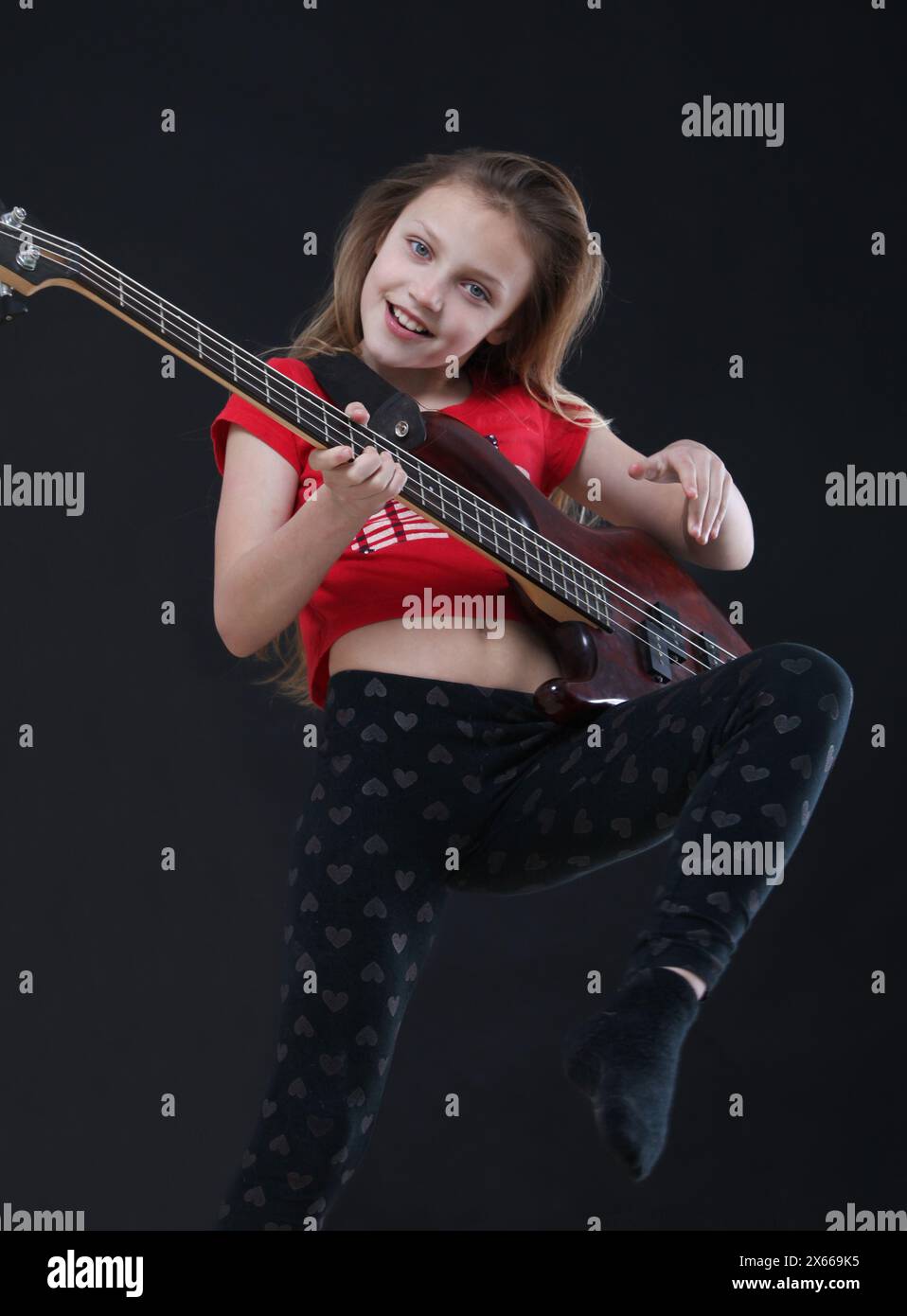 enthusiastic girl playing bass guitar Stock Photo - Alamy