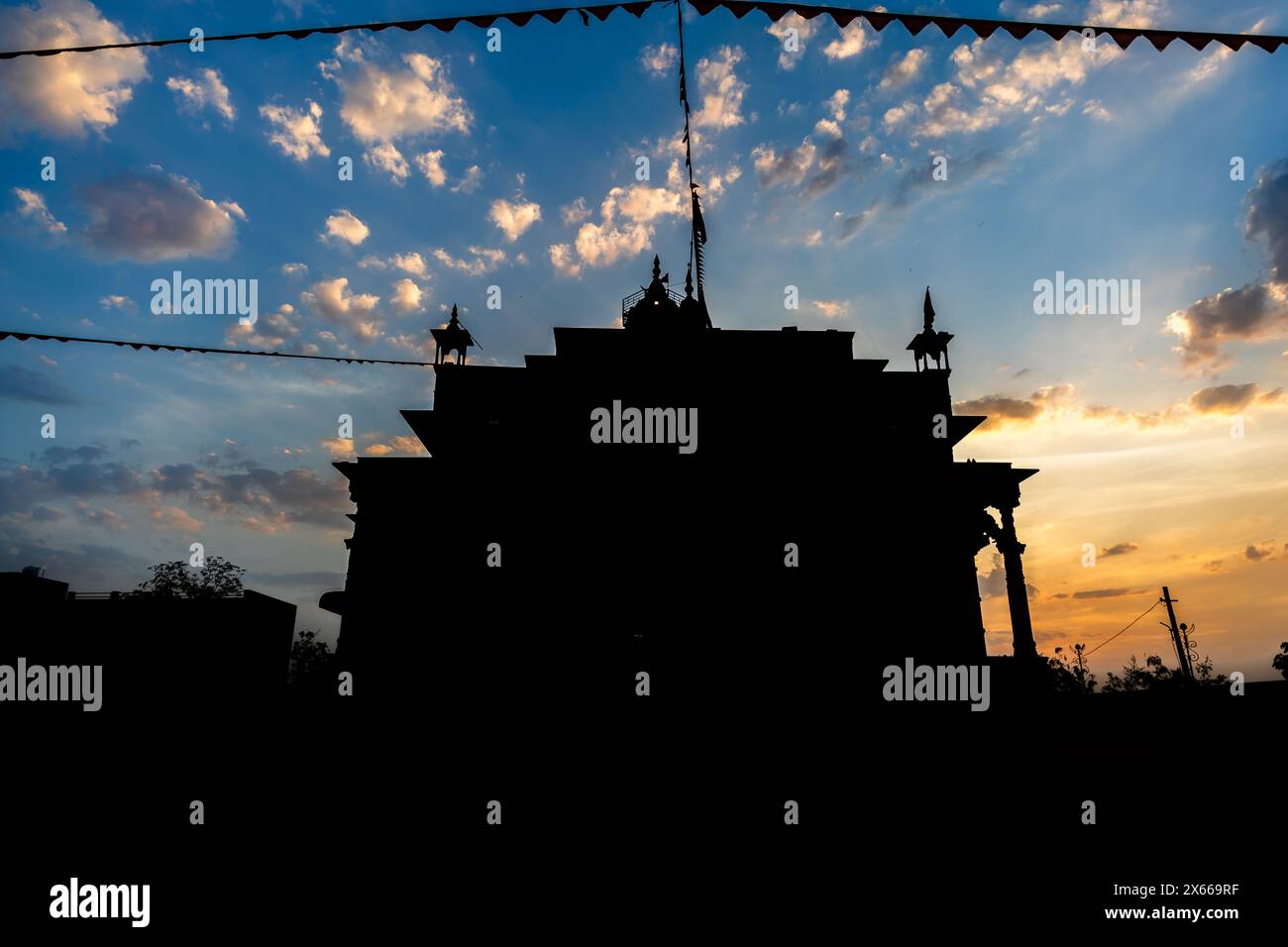 backlit shot of dramatic sunset sky and artistic hindu temple at ...