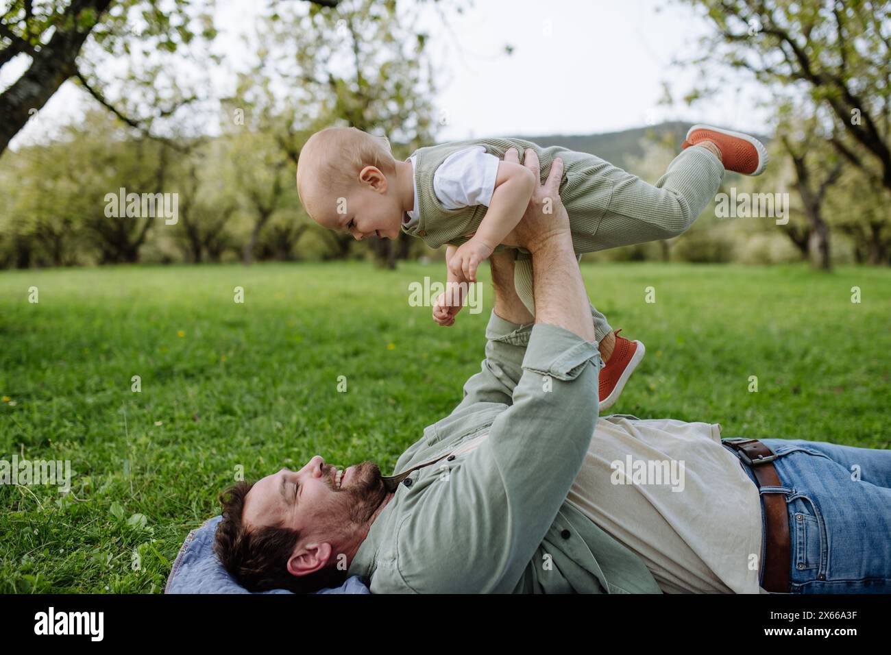 Father holding little baby, playing, having fun during warm spring day ...