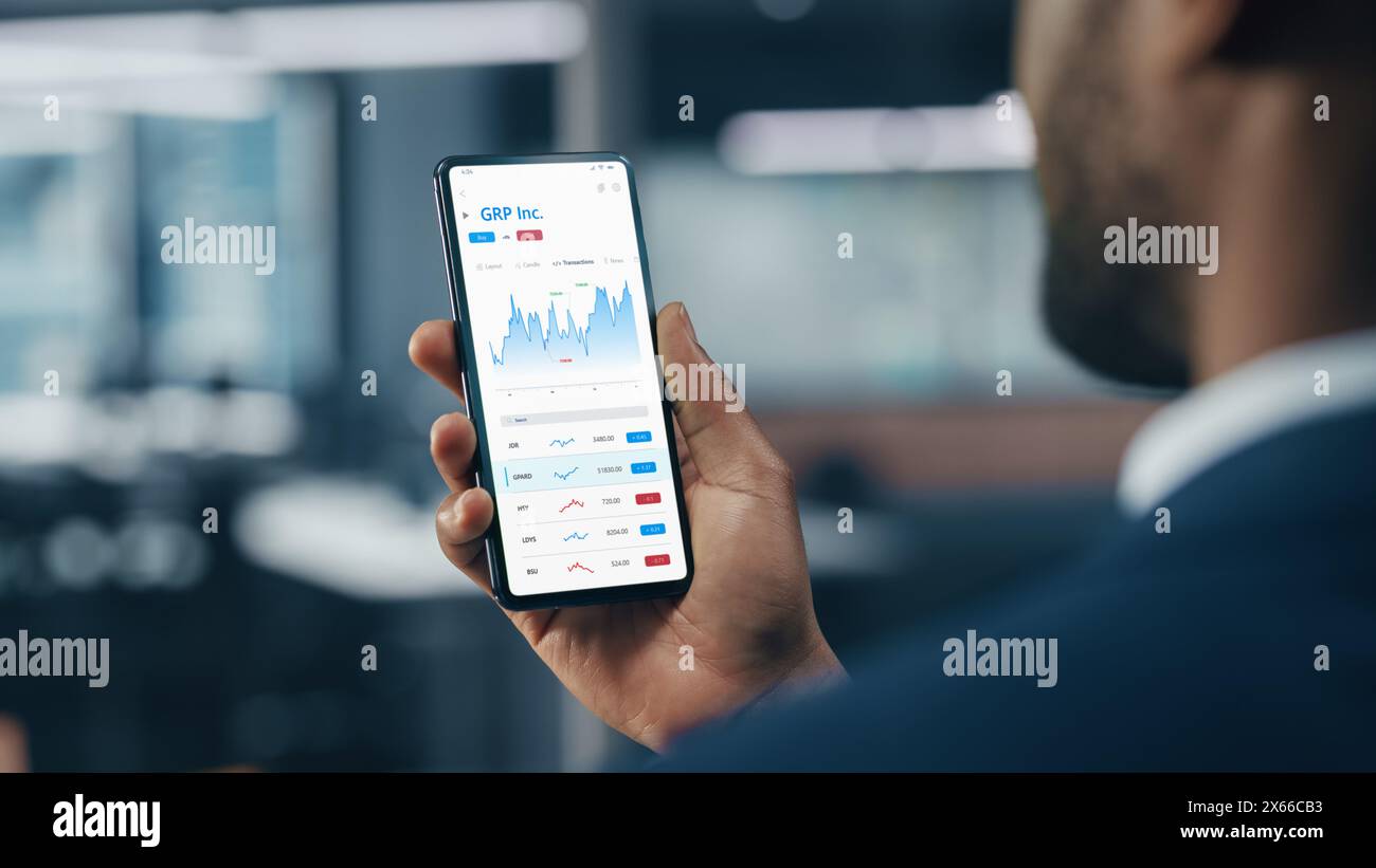 Black Businessman Holding Smartphone and Checking Stock and ...
