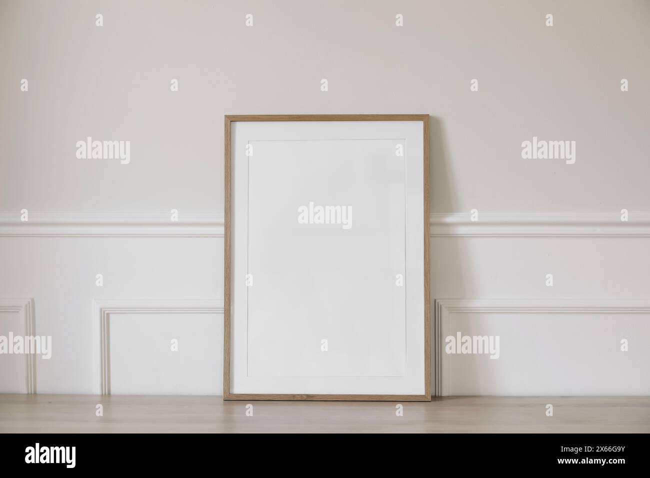 Minimal empty vertical wooden picture frame mockup. White wall with ...