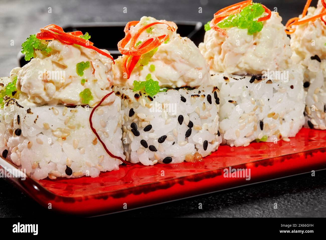 Elegant sushi roll with creamy seafood toppings and green tobiko Stock ...