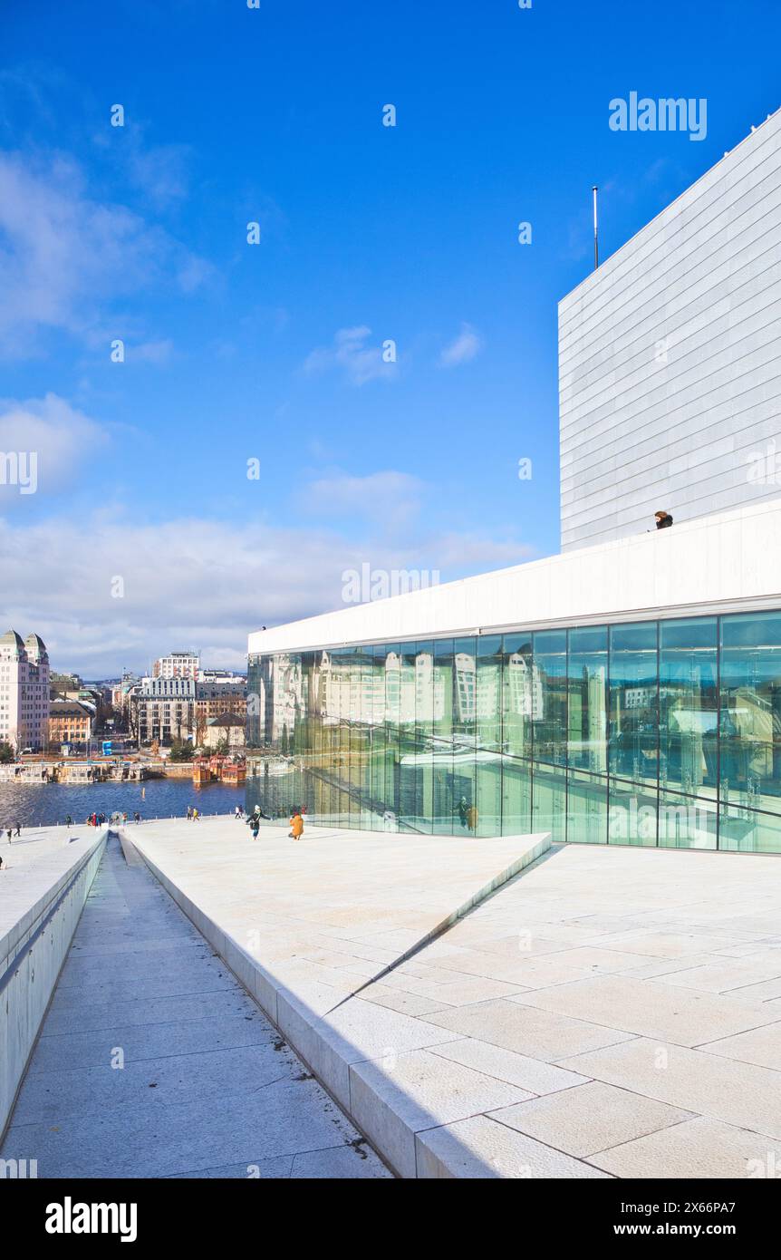 Tourists walking up the sloping roof of Oslo Opera House (Operahuset ...
