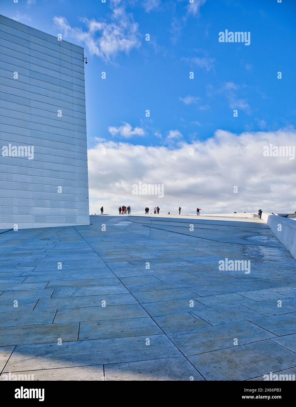 Tourists silhouetted standing on the roof of Oslo Opera House ...