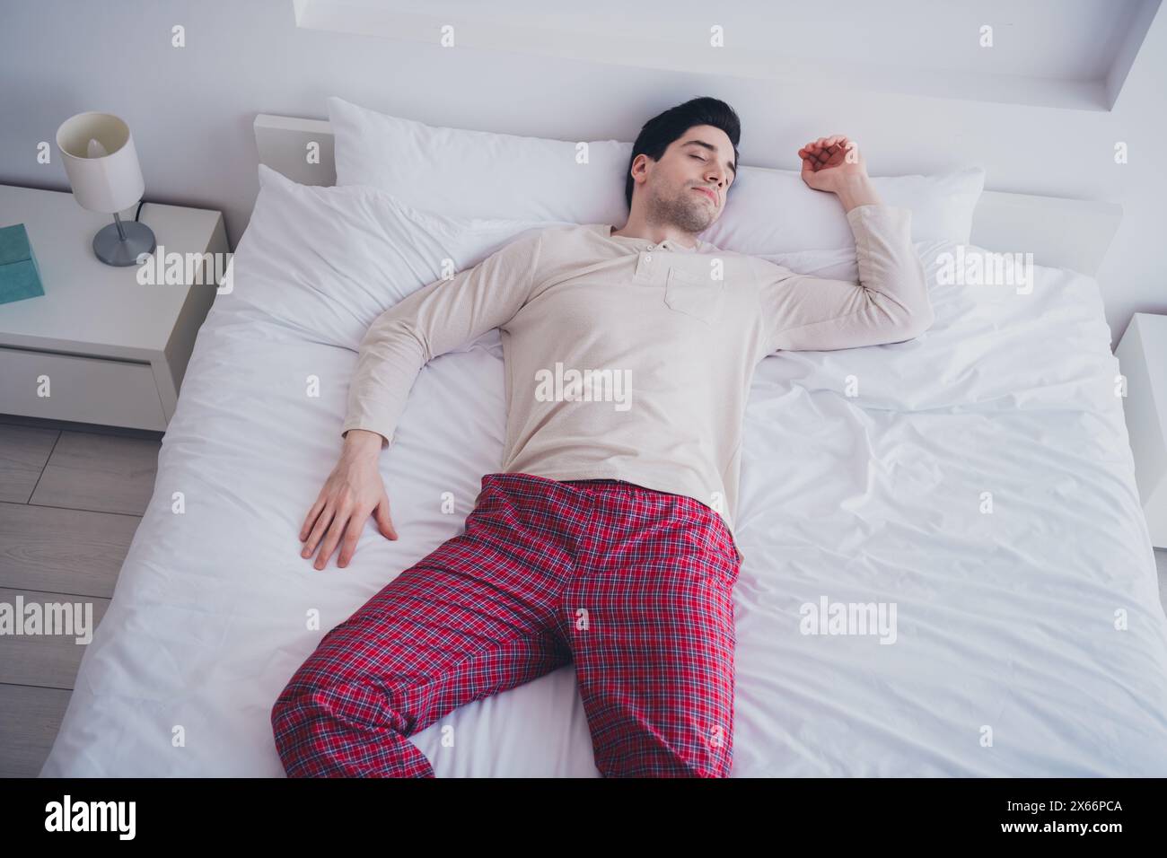 Photo of young attractive man peaceful sleeping lying in soft comfy bed ...