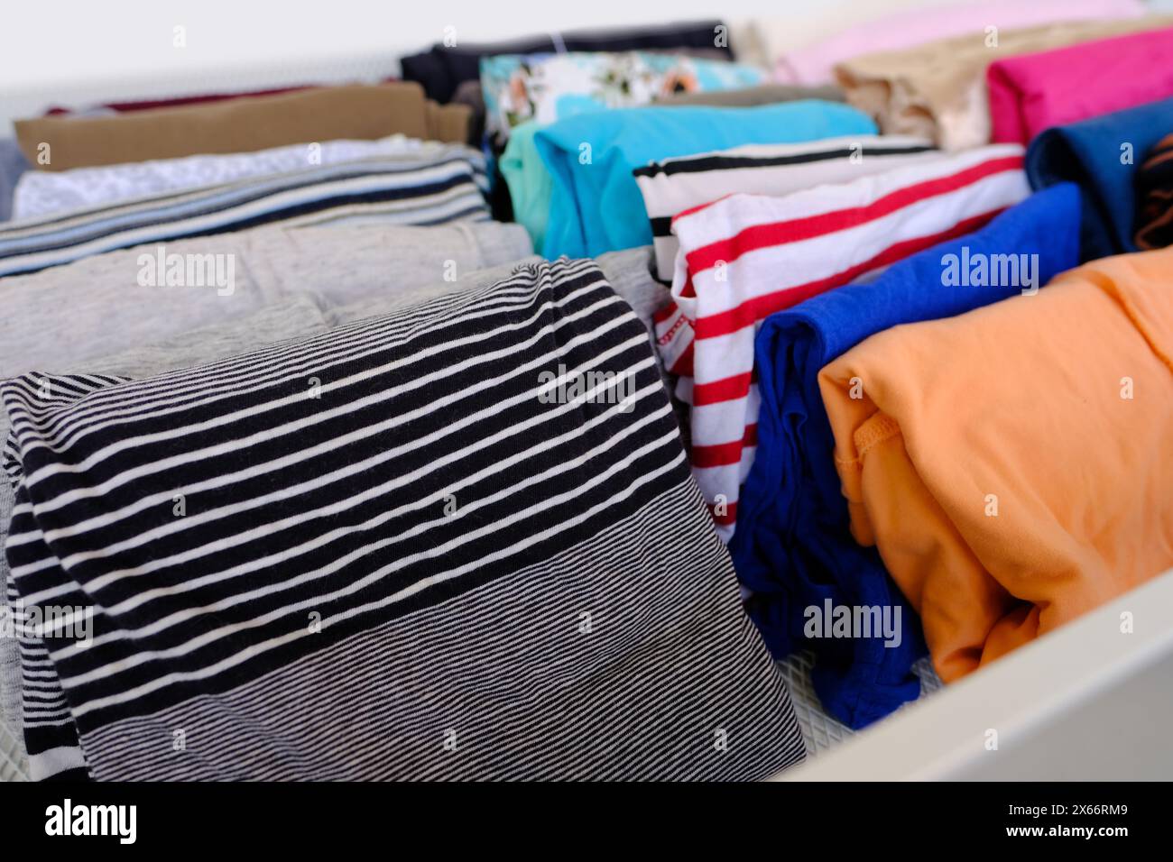 bunch of colorful clothes, woman is cleaning out her wardrobe, Vertical ...