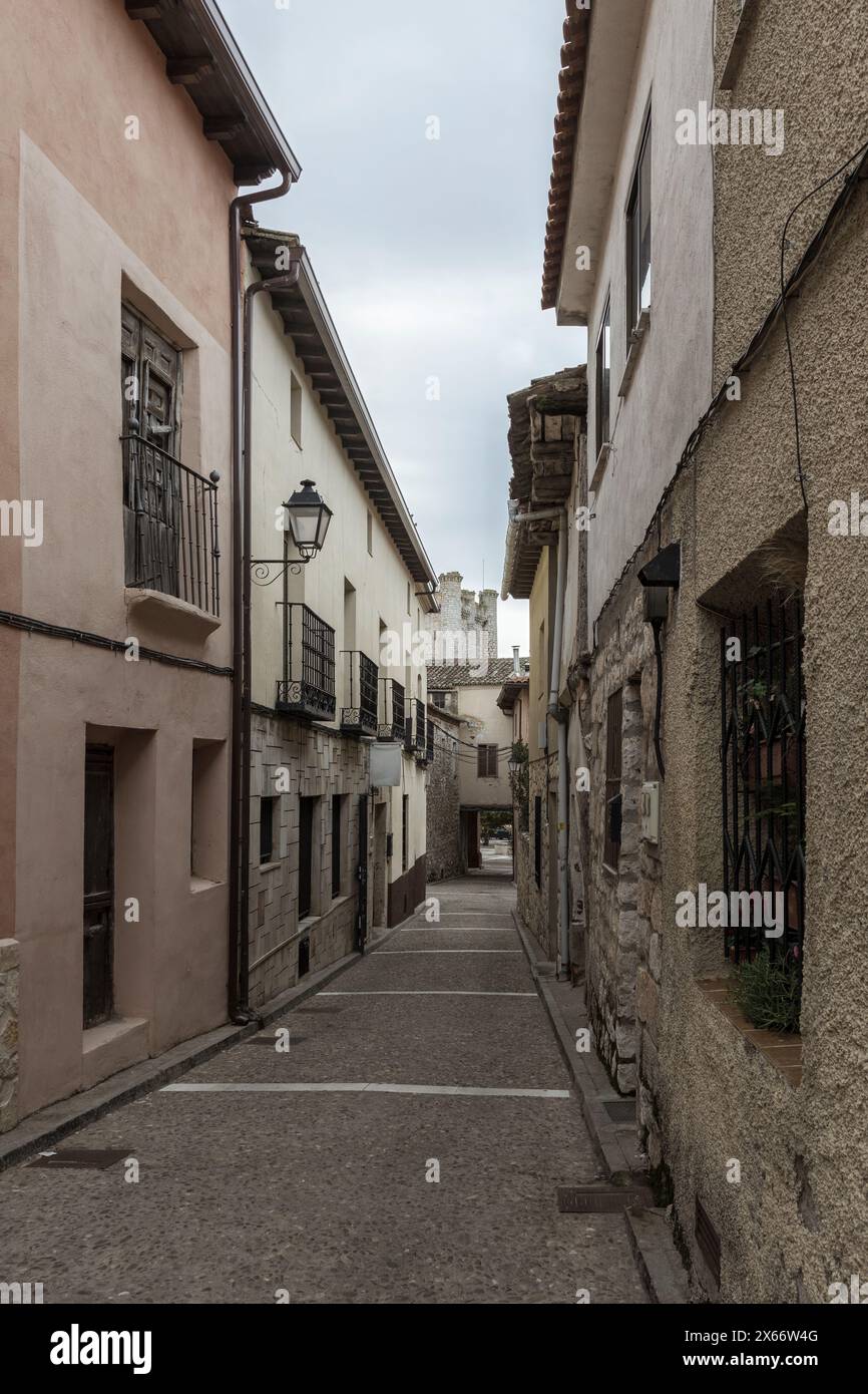 narrow, stone-paved street flanked by old, textured buildings under a ...