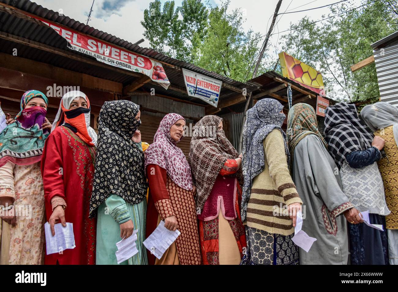 Kashmir, India. 13th May, 2024. Kashmiri women queue up to cast their ...