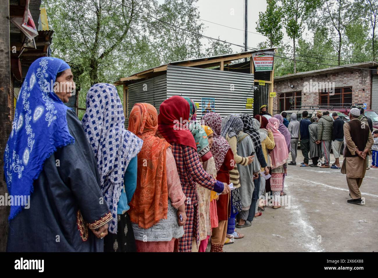 Kashmir, India. 13th May, 2024. Kashmiri voters queue up to cast their ...