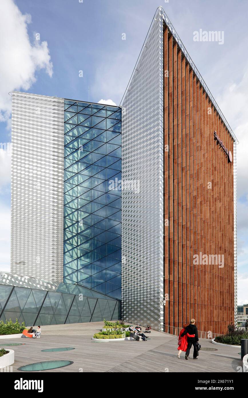 Tower building with wood elevation and couple walking. SwedBank Vilnius ...