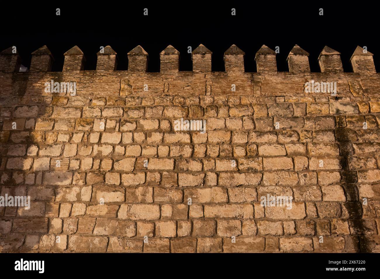Wall of the Real Alcazar at night in Seville, Spain, stone ...