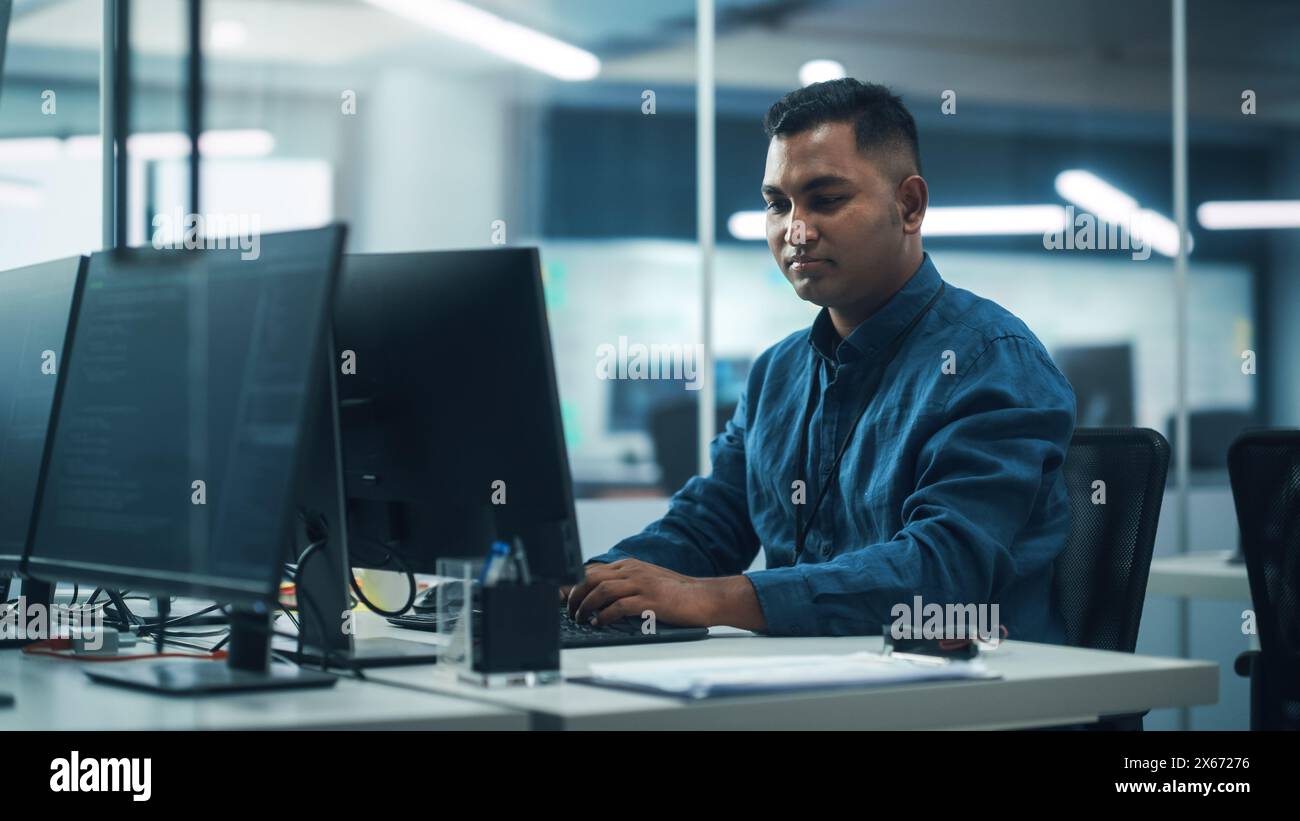 In Diverse Office Portrait Of Handsome Indian Man Working On Desktop Computer Professional