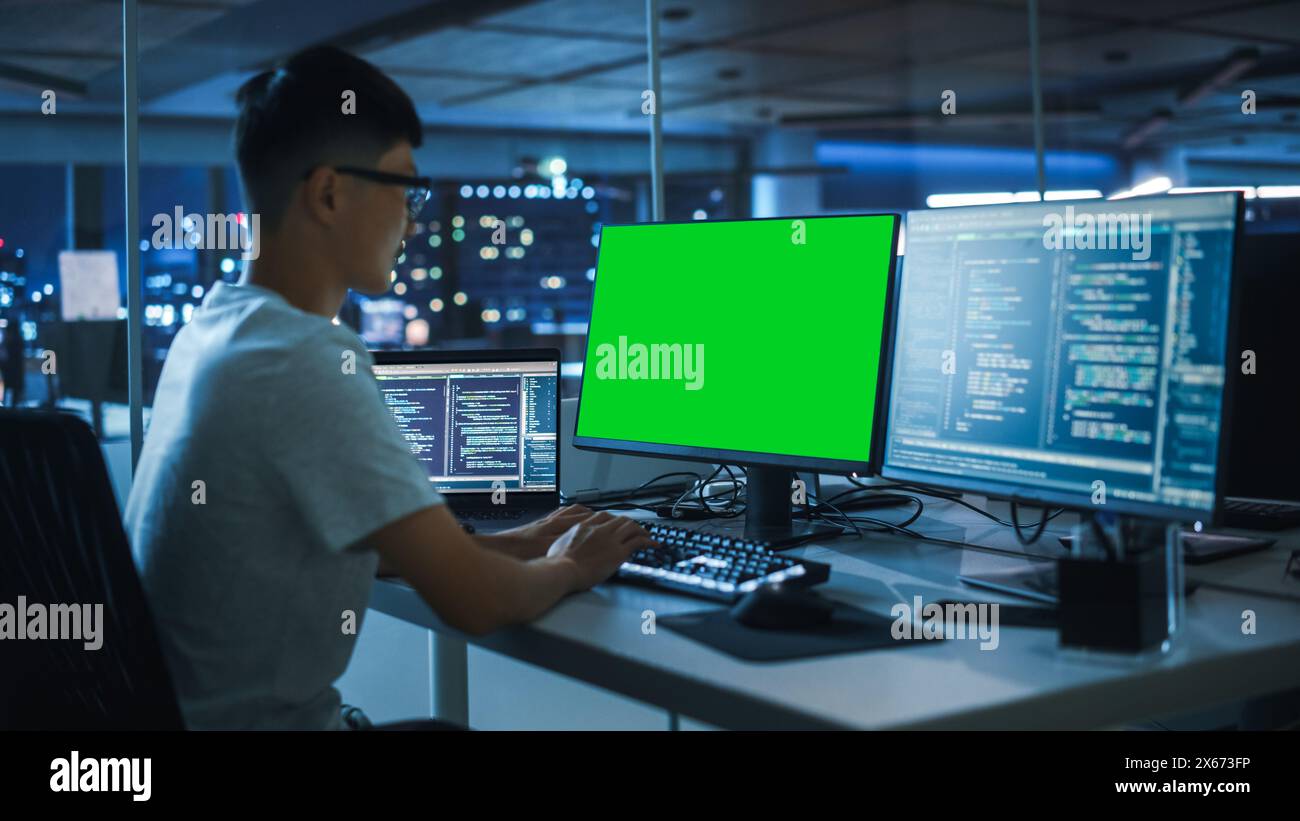 Night Office: Young Japanese Man in Working on Green Screen Chroma Key Desktop Computer ...