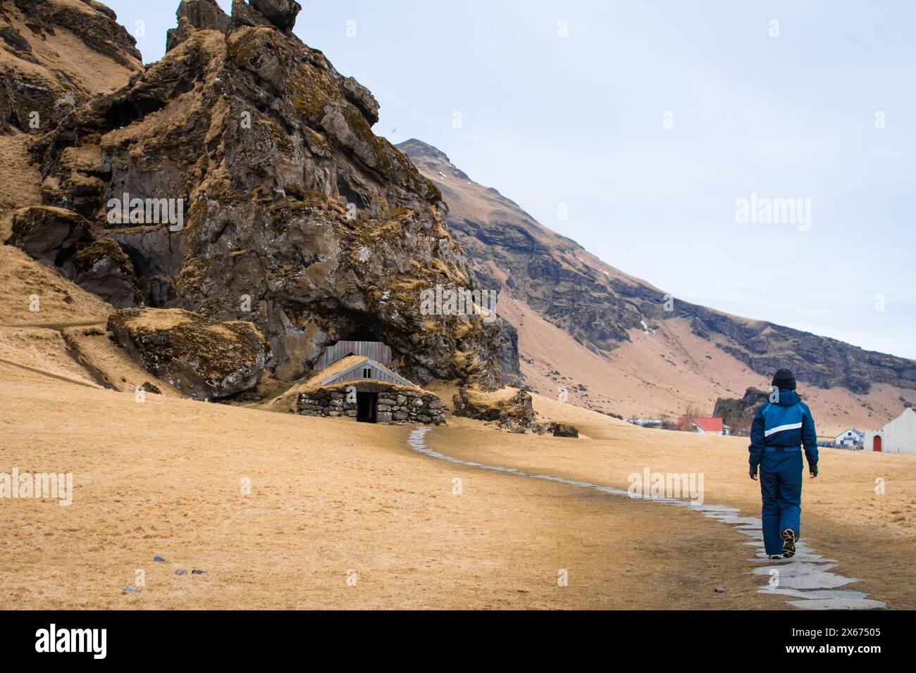 Woman Tourist visit turf house and Drangurinn Rock in Southern Iceland ...