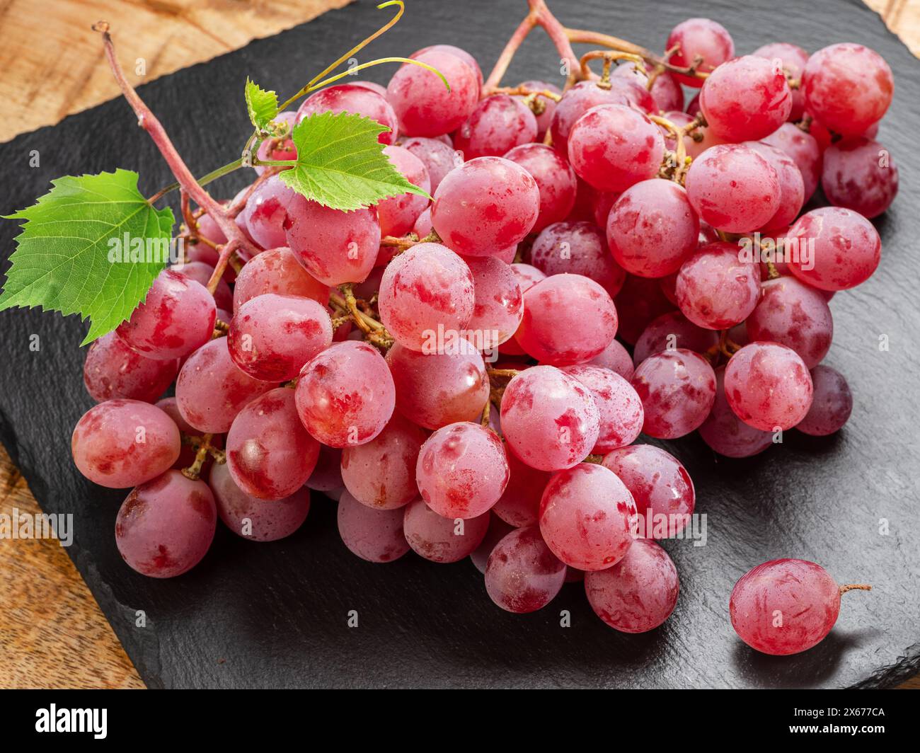 Cluster of red table grape with grape leaves isolated on white ...