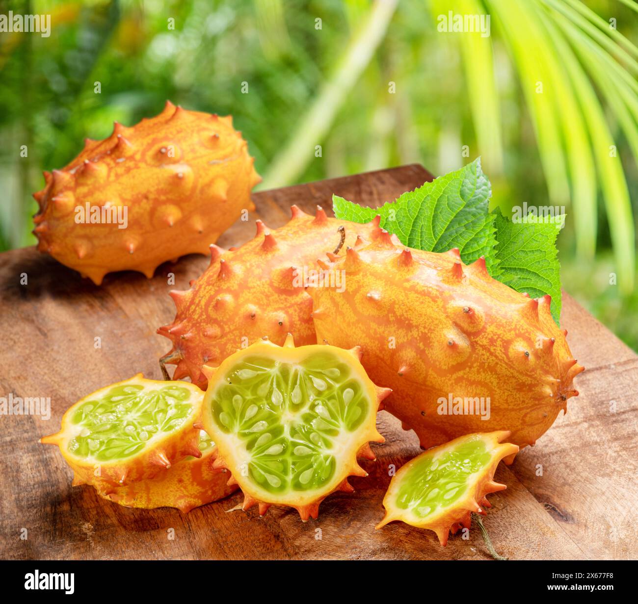Kiwano fruit with kiwano slices on wooden background. Blurred tropical ...