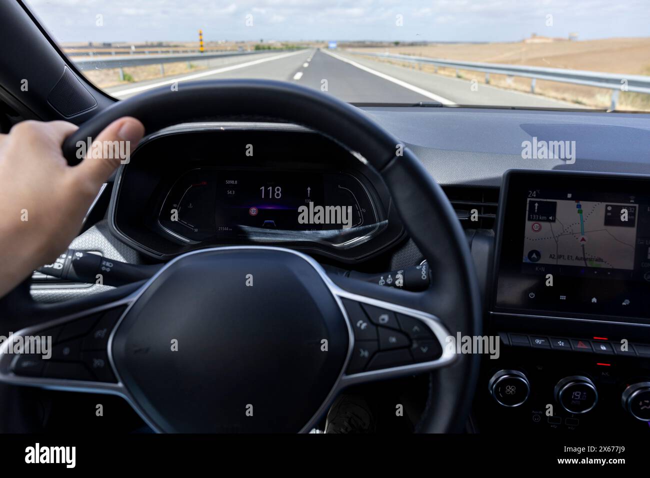Driver view to the speedometer at 118 kmh, on a road blurred. Daylight ...